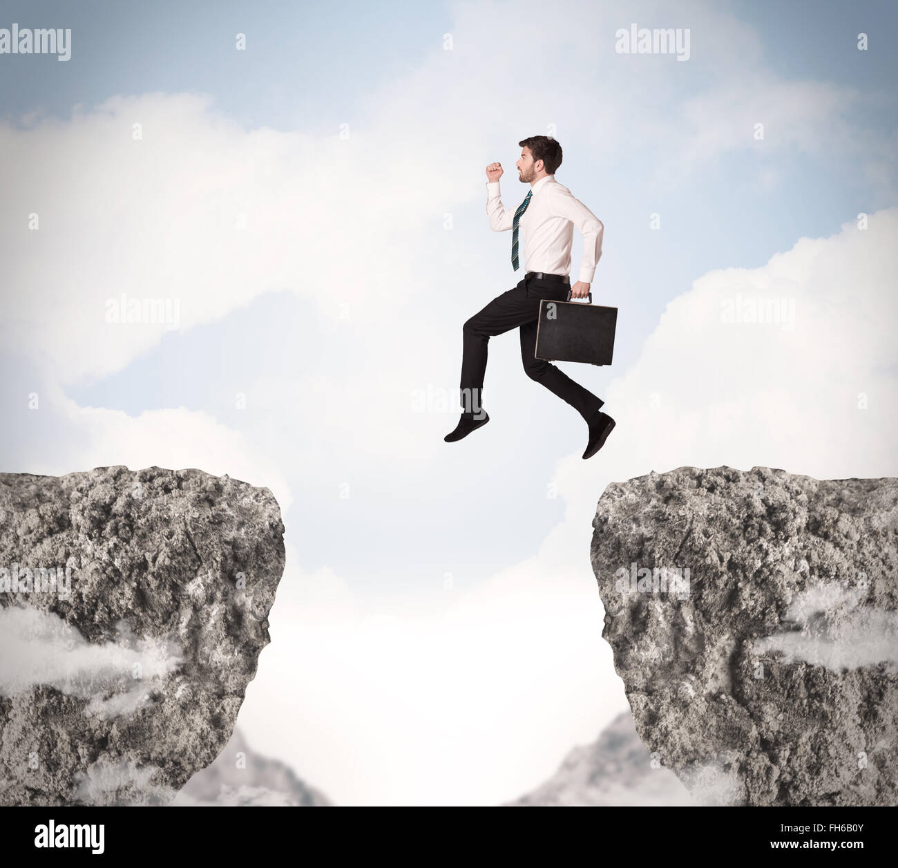 Funny business man jumping over rocks with gap Stock Photo - Alamy