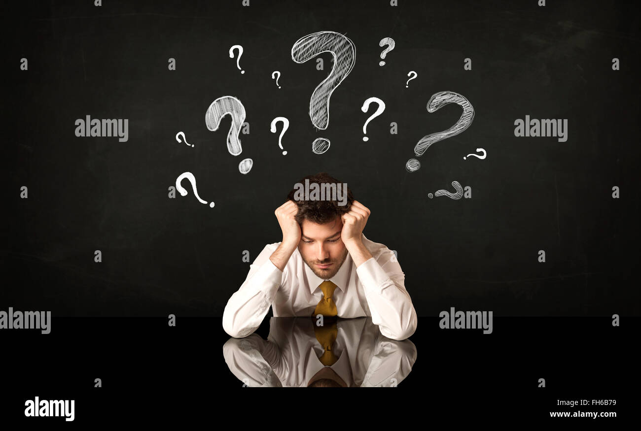 Sitting businessman under question marks Stock Photo - Alamy