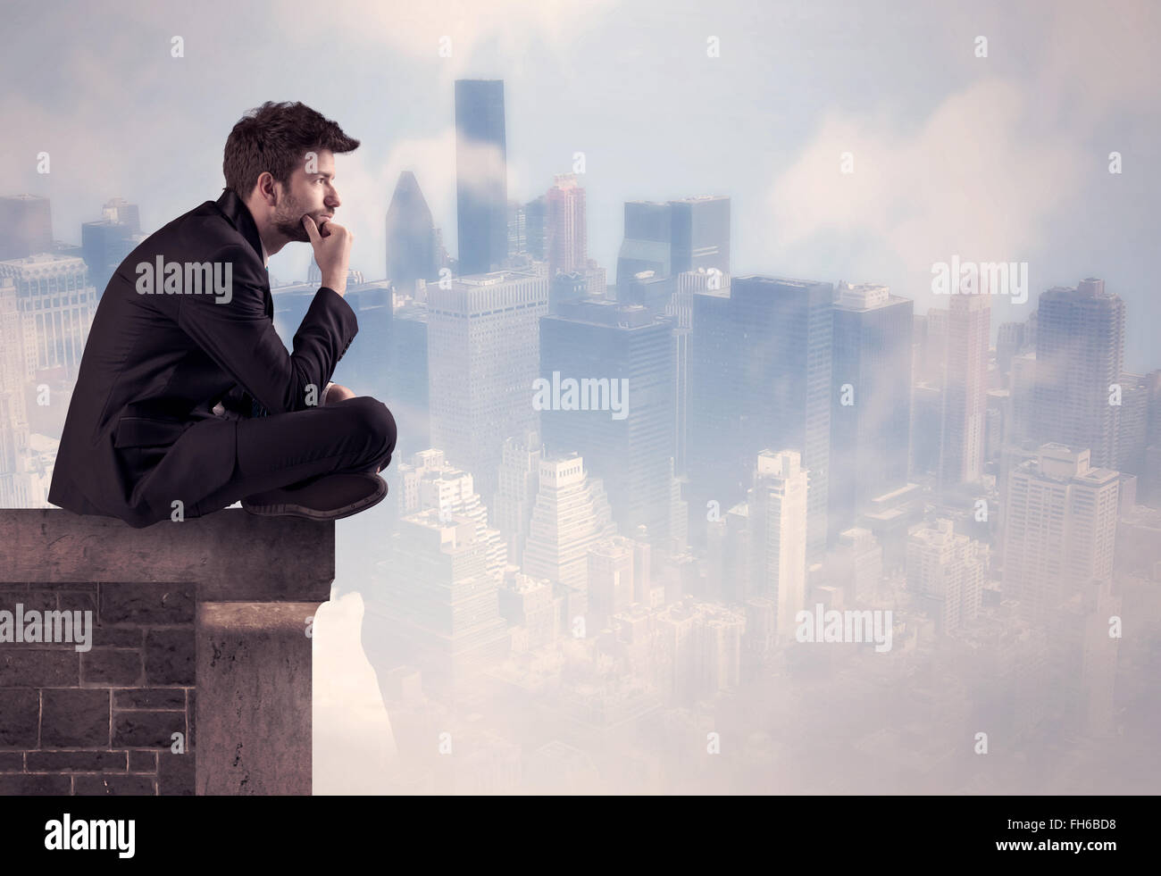 Sales person sitting on top of a tall building Stock Photo - Alamy