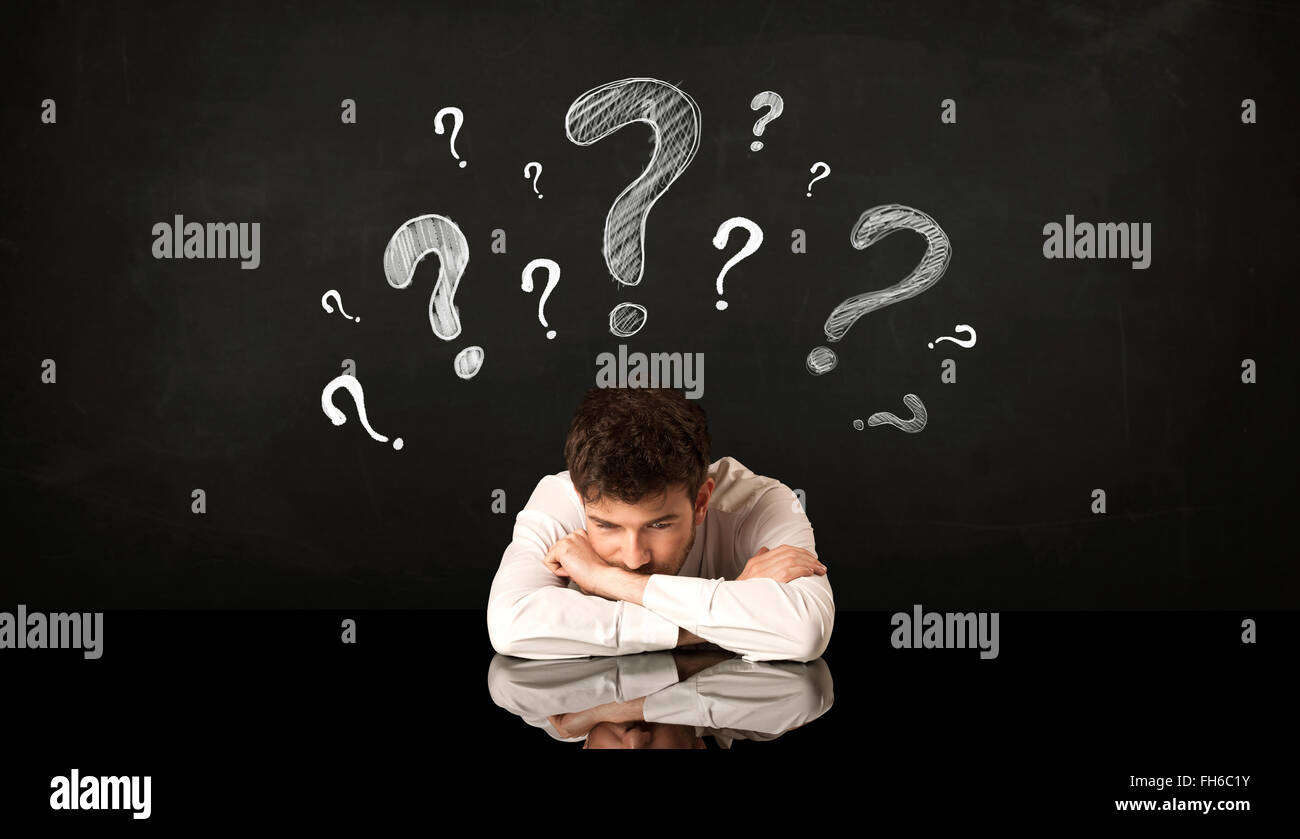 Sitting businessman under question marks Stock Photo - Alamy
