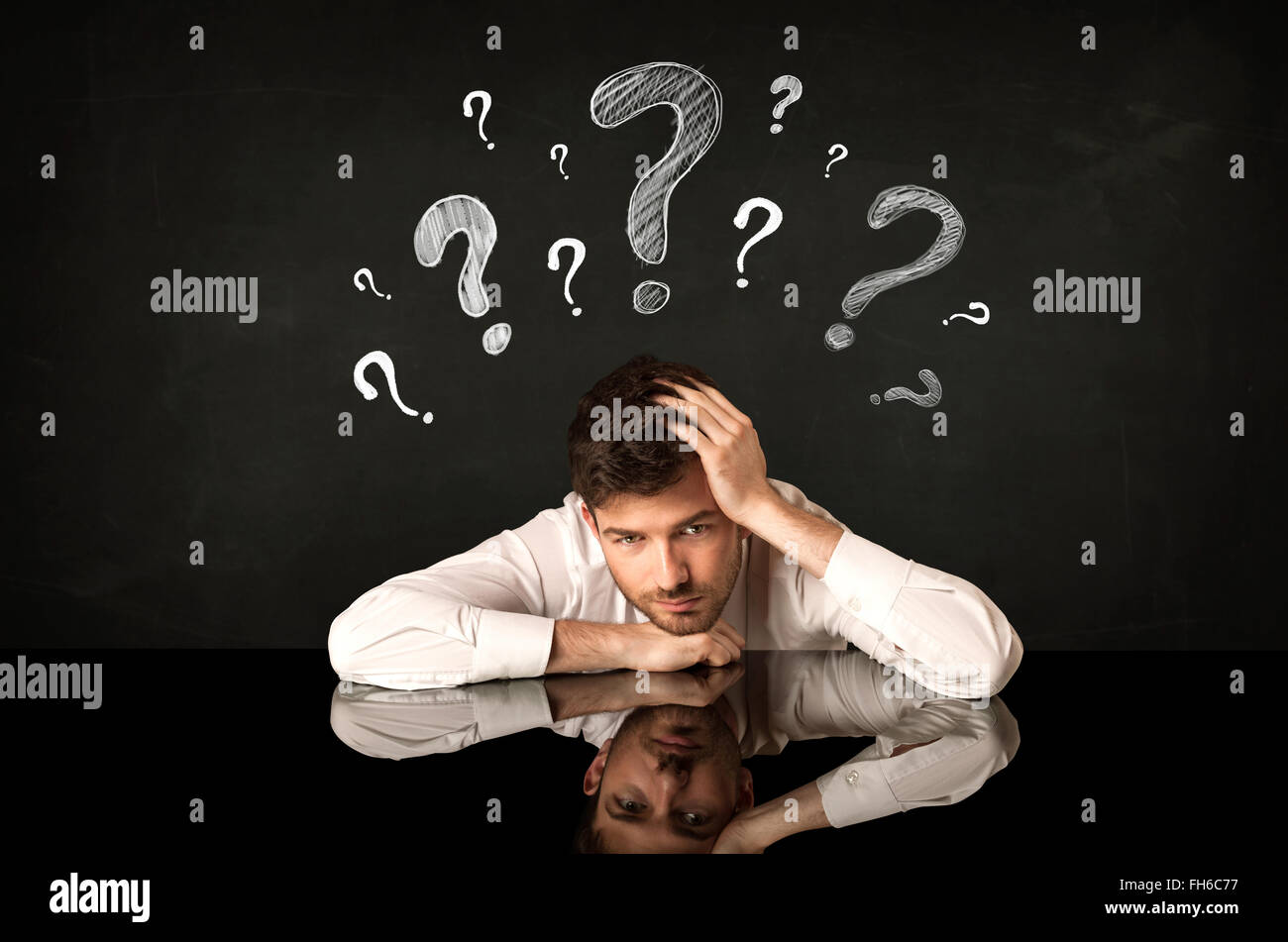 Sitting businessman under question marks Stock Photo - Alamy