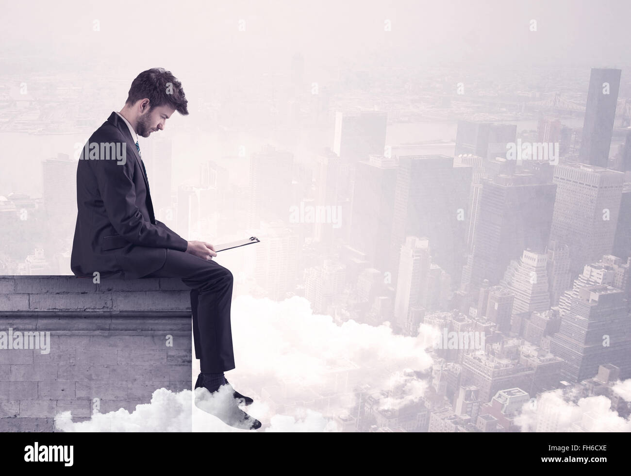 Sales person sitting on building edge in city Stock Photo - Alamy