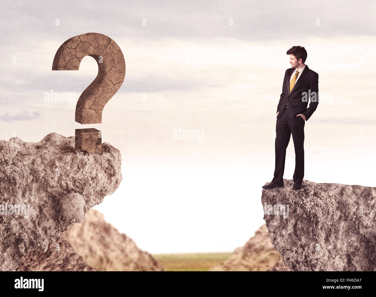 Businessman on rock mountain with a question mark Stock Photo - Alamy