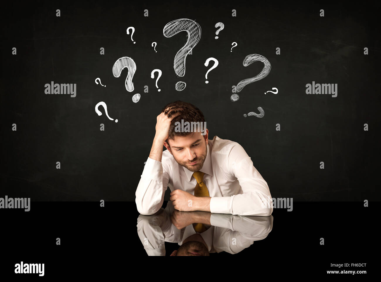 Sitting businessman under question marks Stock Photo - Alamy