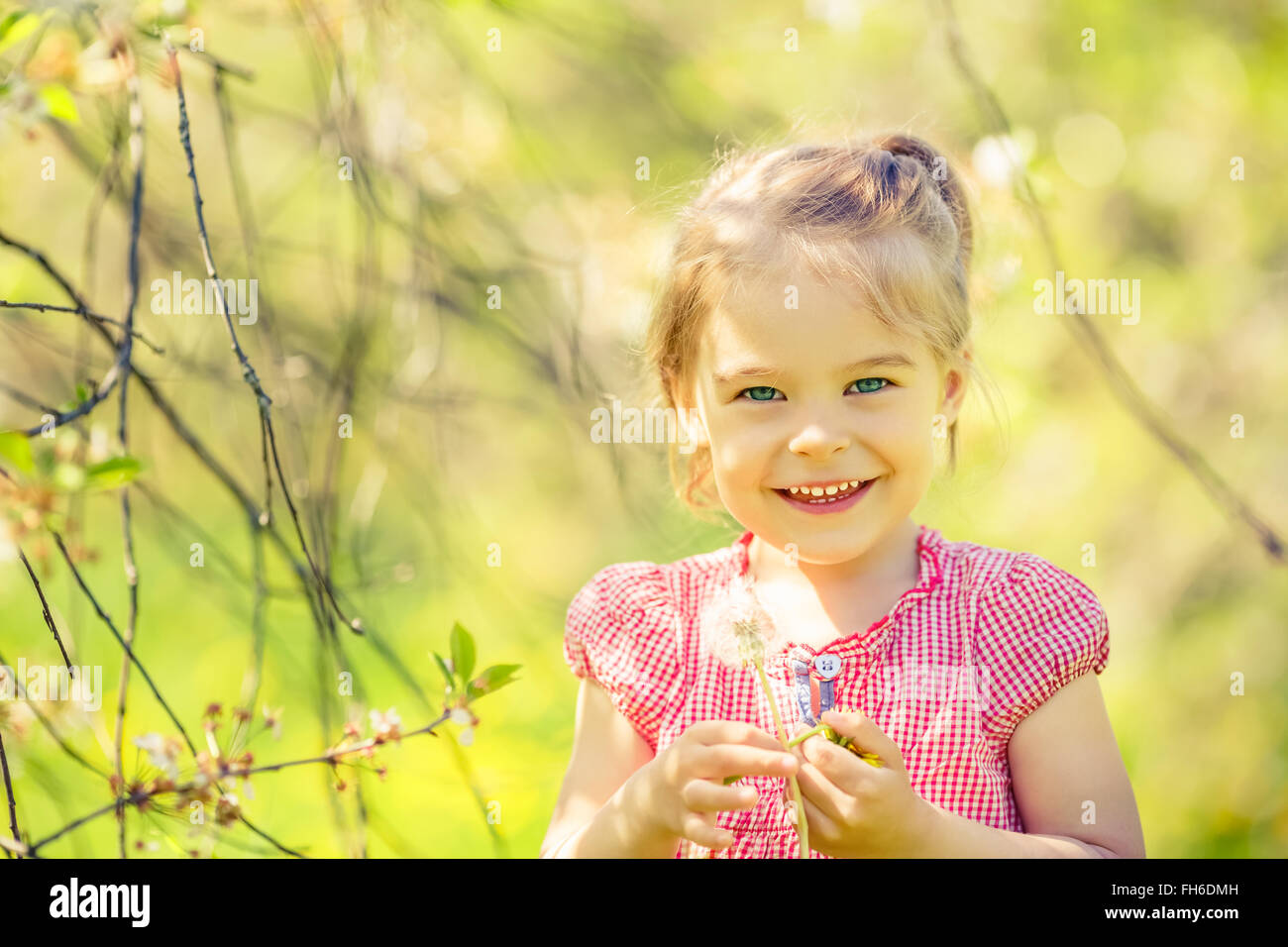 Happy little girl in spring sunny park Stock Photo - Alamy