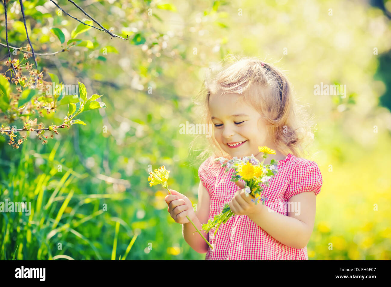 Happy little girl in spring sunny park Stock Photo - Alamy