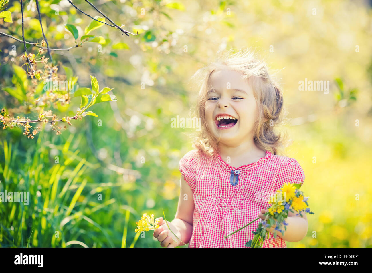 Happy little girl in spring sunny park Stock Photo - Alamy