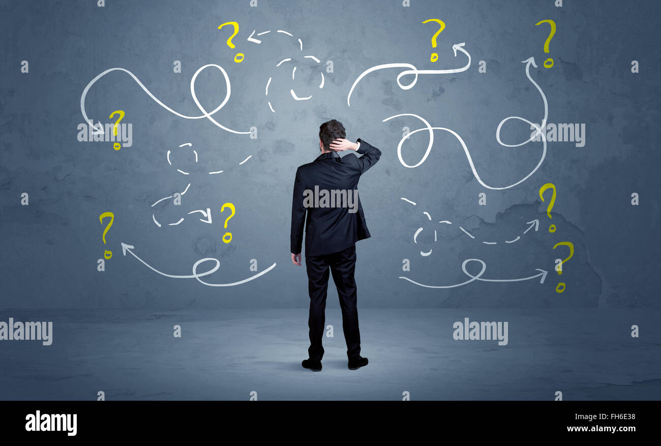 Unsure businessman with question marks Stock Photo - Alamy