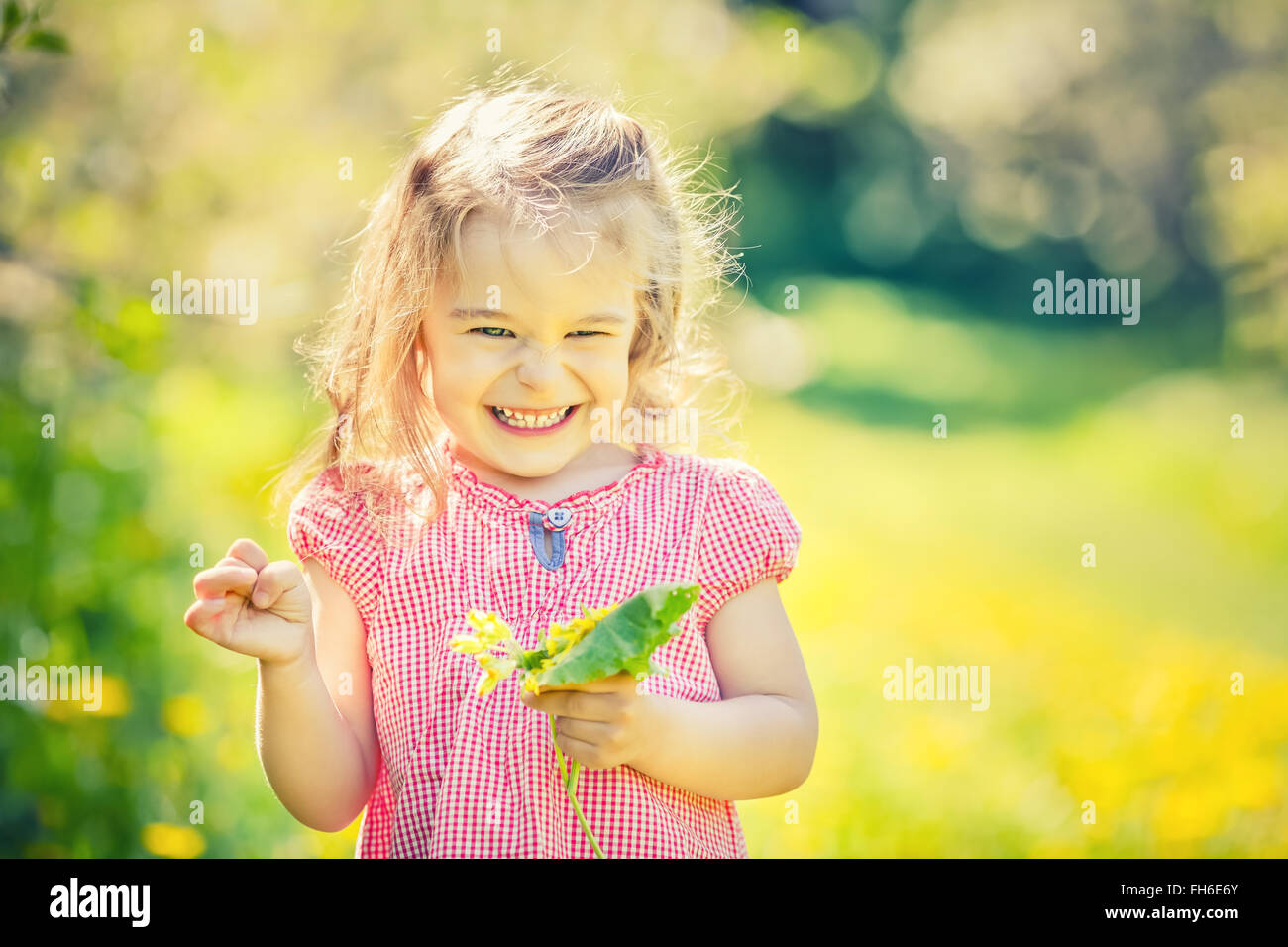 Happy little girl in spring sunny park Stock Photo - Alamy