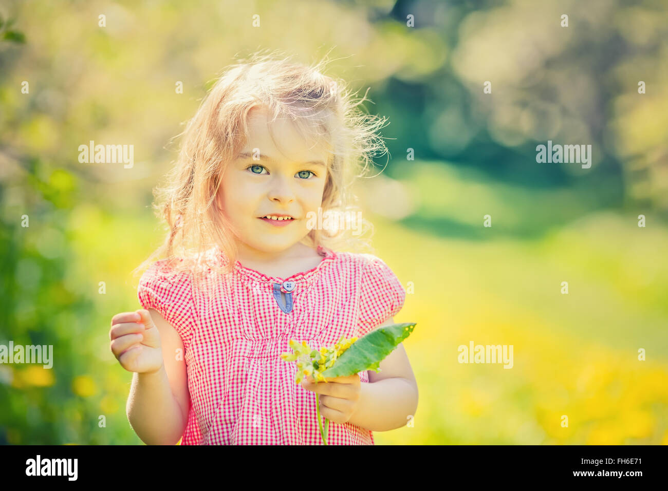 Happy little girl in spring sunny park Stock Photo - Alamy