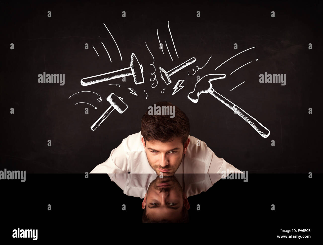 Depressed businessman sitting under hammer marks Stock Photo - Alamy