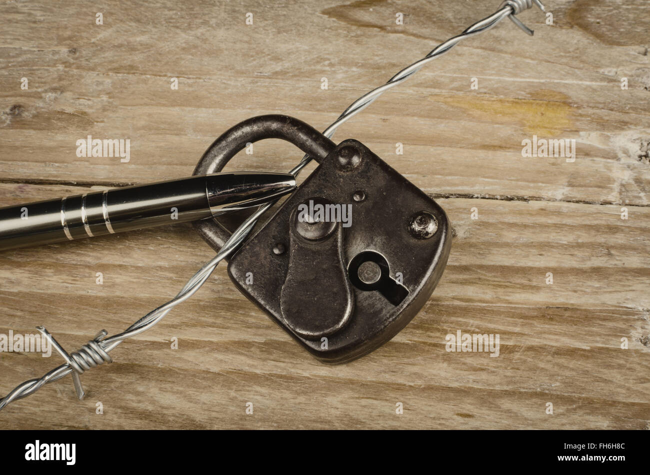 Pen, barbed wire and padlock, a press freedom concept Stock Photo - Alamy
