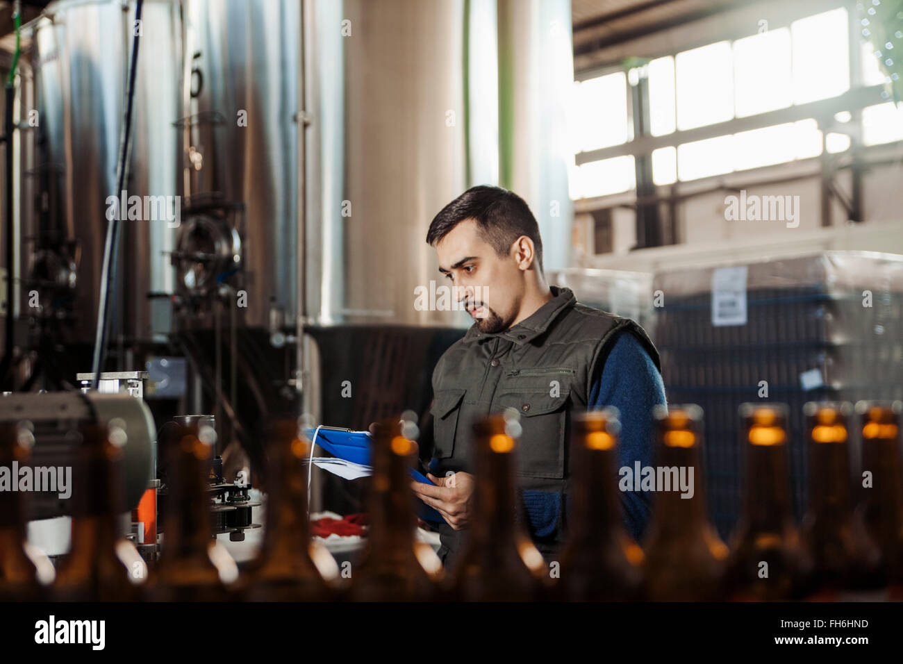 Young man working in craft brewery Stock Photo - Alamy