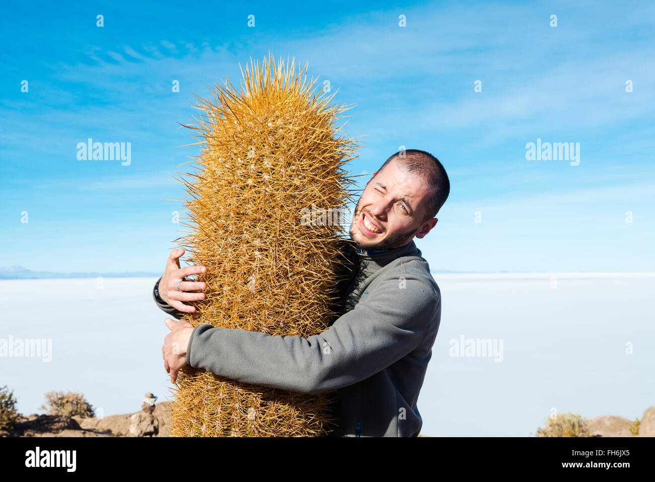 Bolivia, Atacama, Altiplano, Salar de Uyuni, man embracing cactus Stock ...