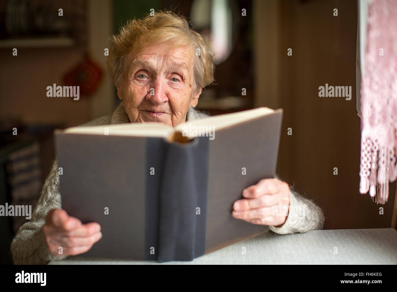 An elderly woman reading a large book Stock Photo - Alamy