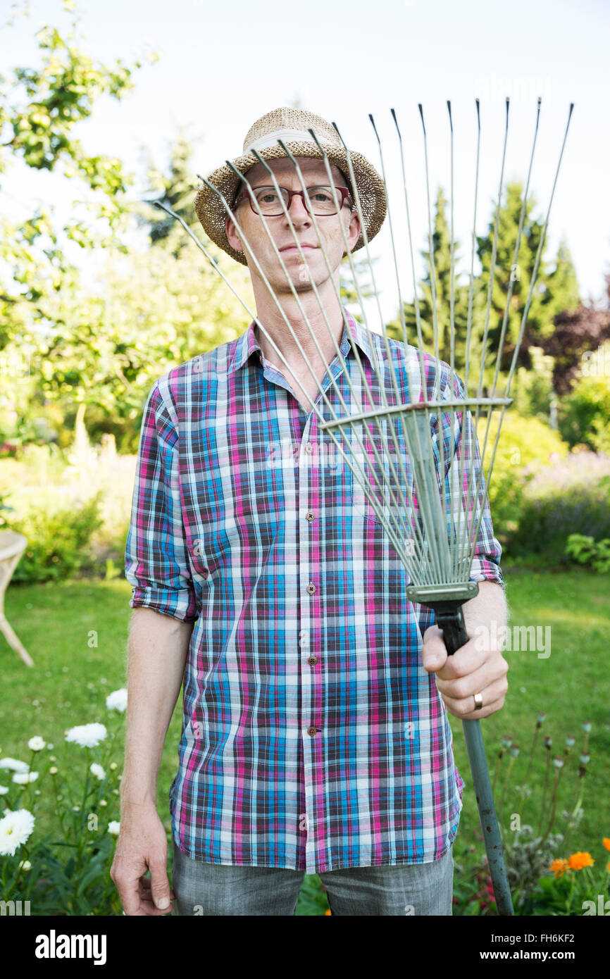 Portrait of allotment gardener with rake Stock Photo - Alamy