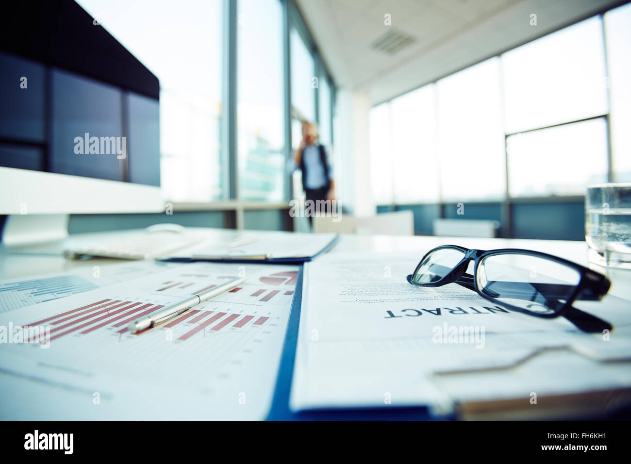 Business documents at workplace and employee on background Stock Photo ...