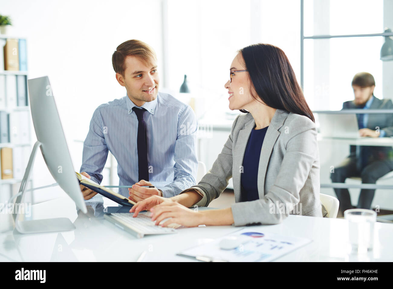 Two colleagues discussing working plans in office Stock Photo - Alamy