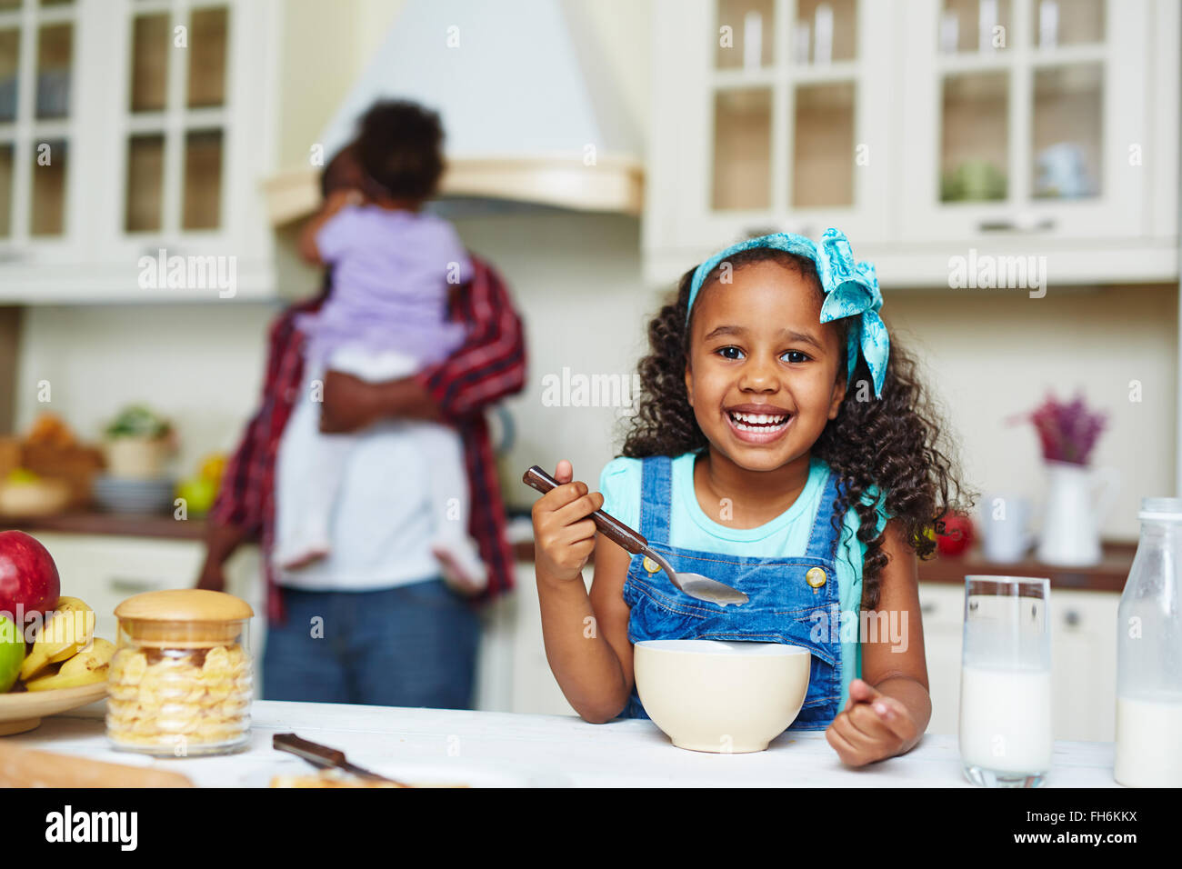 Happy African-American girl eating morning cornflakes Stock Photo - Alamy