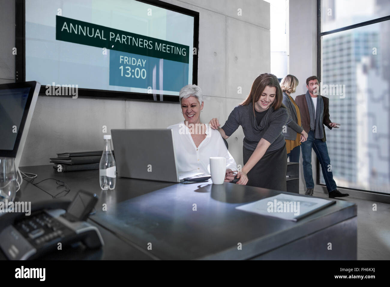 Happy colleagues talking in office Stock Photo - Alamy