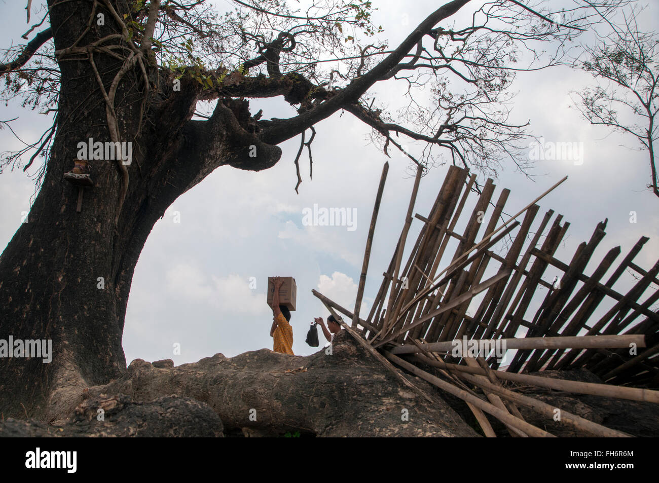 A Cyclone Nargis survivor carries food and water container donated by ...