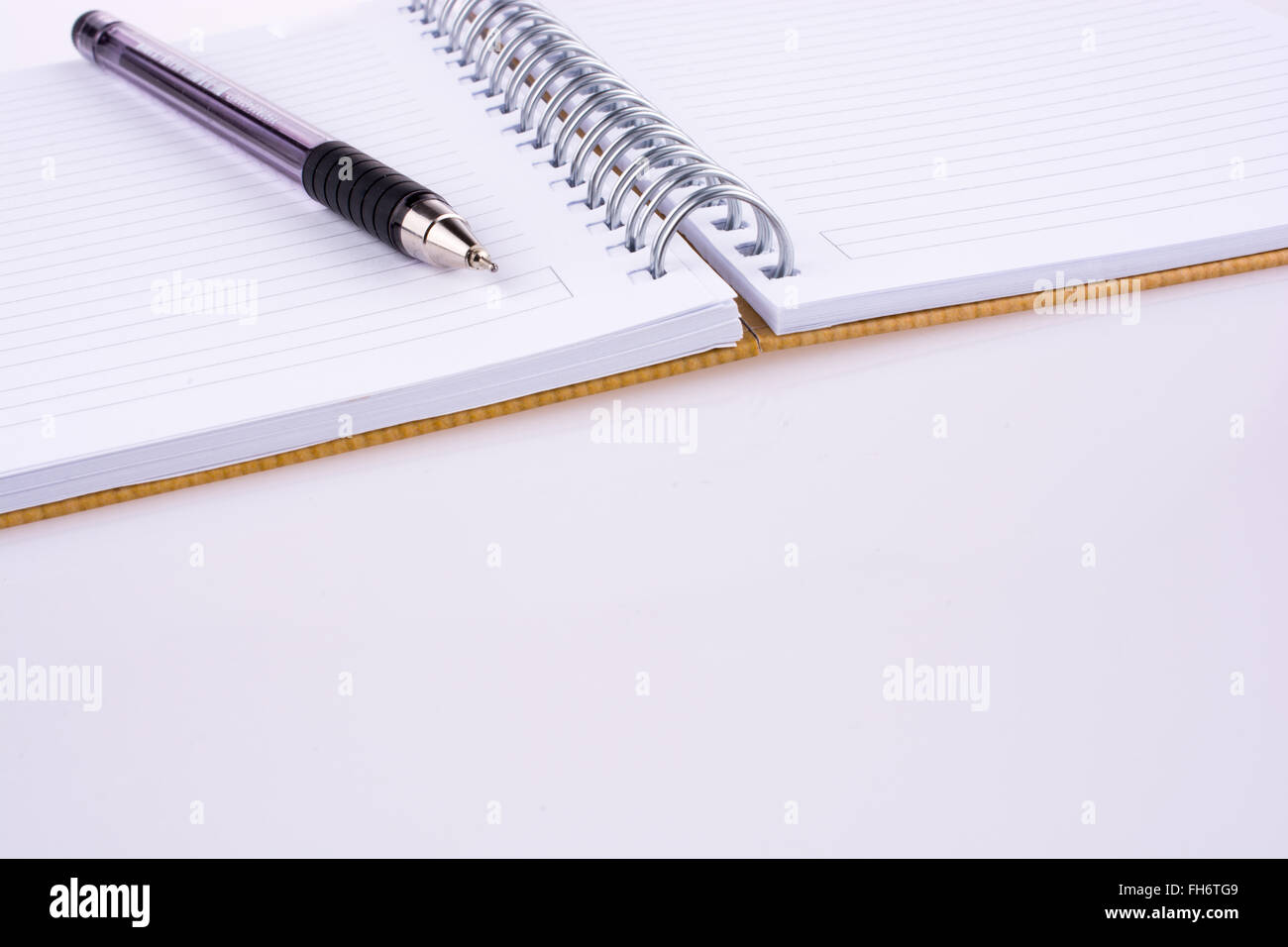 Pen on notebook on a white background Stock Photo - Alamy
