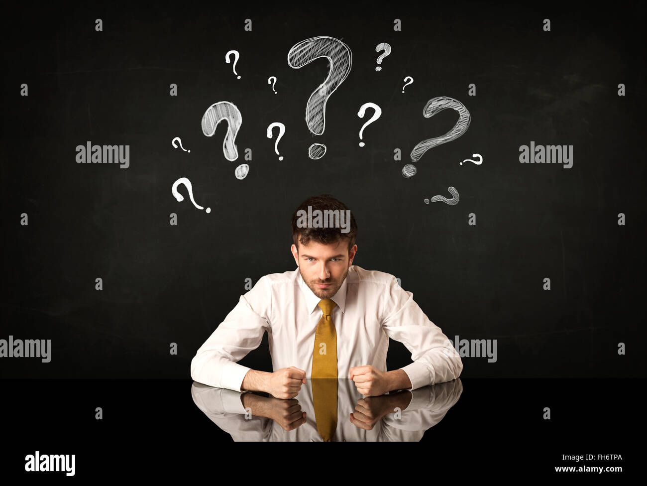 Sitting businessman under question marks Stock Photo - Alamy