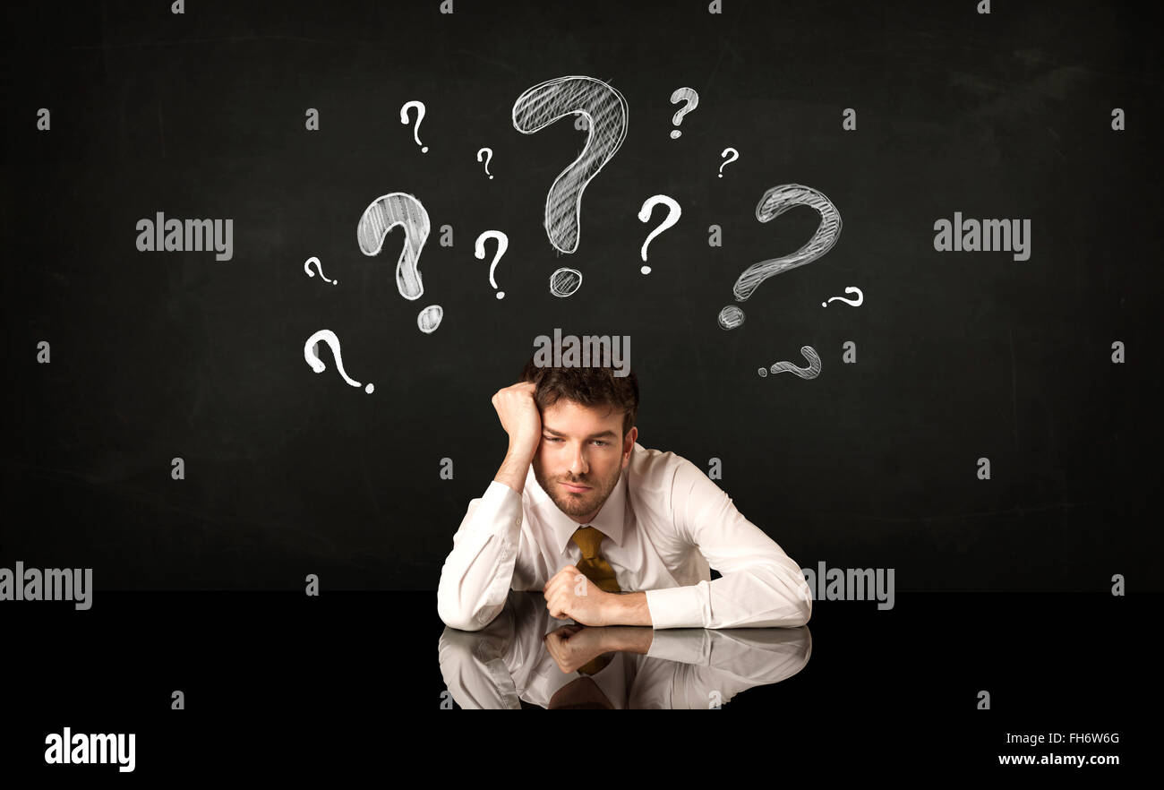 Sitting businessman under question marks Stock Photo - Alamy