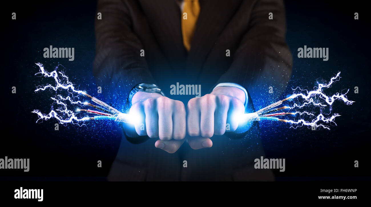 Business person holding electrical powered wires Stock Photo - Alamy