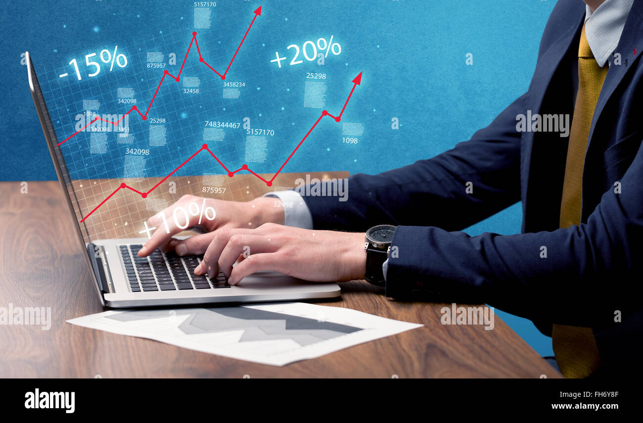 Salesman working on graph with laptop Stock Photo - Alamy