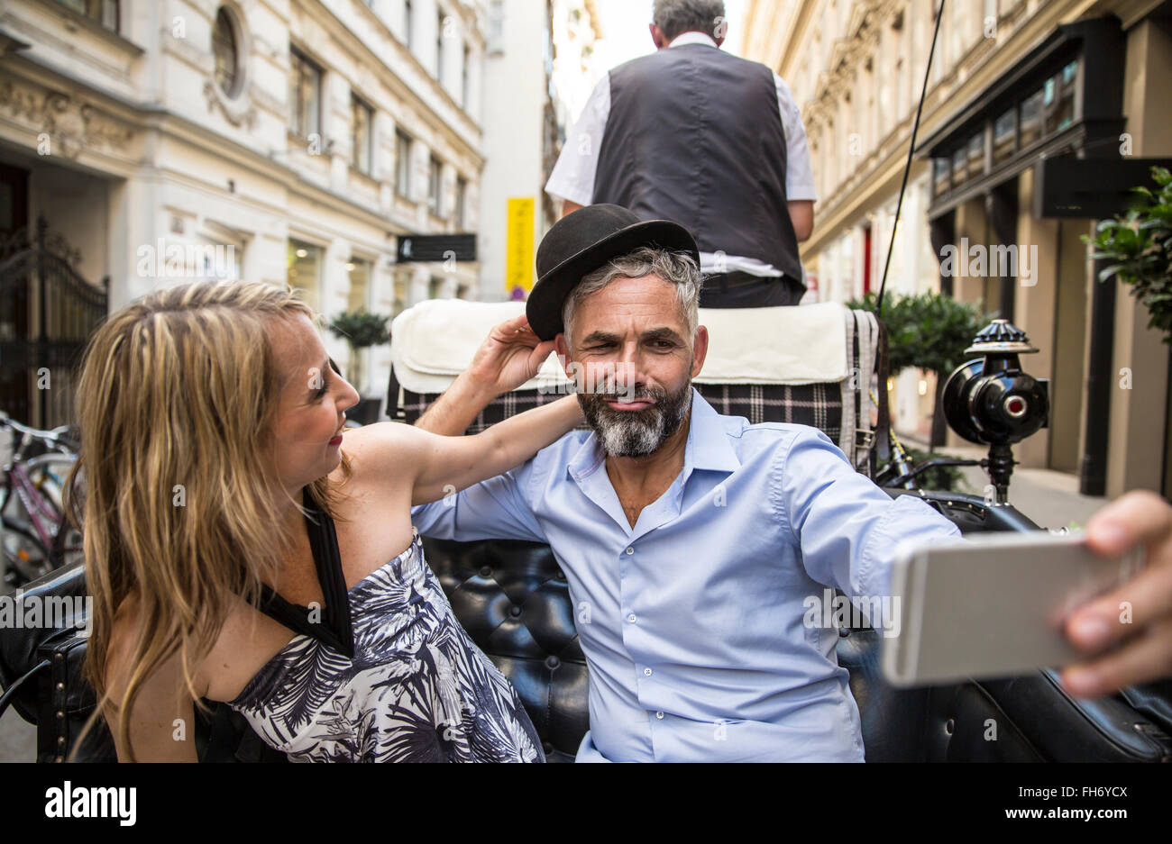 Austria, Vienna, couple having fun on sightseeing tour in a fiaker ...