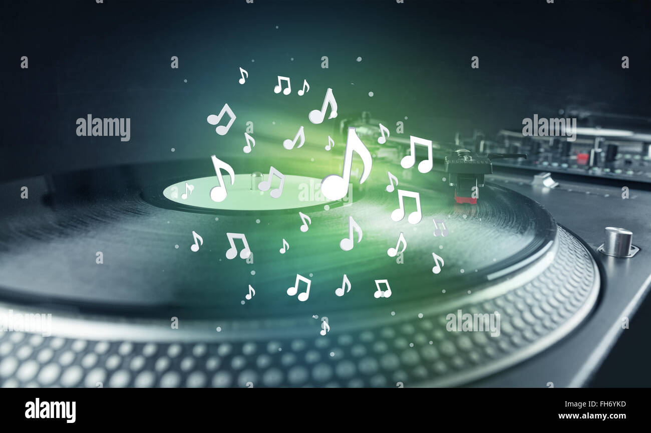 Turntable playing music with audio notes glowing Stock Photo - Alamy