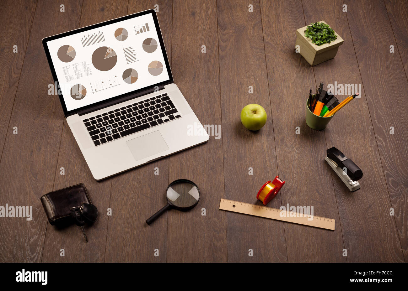 Pie chart graph icons on laptop screen with office accessories Stock ...