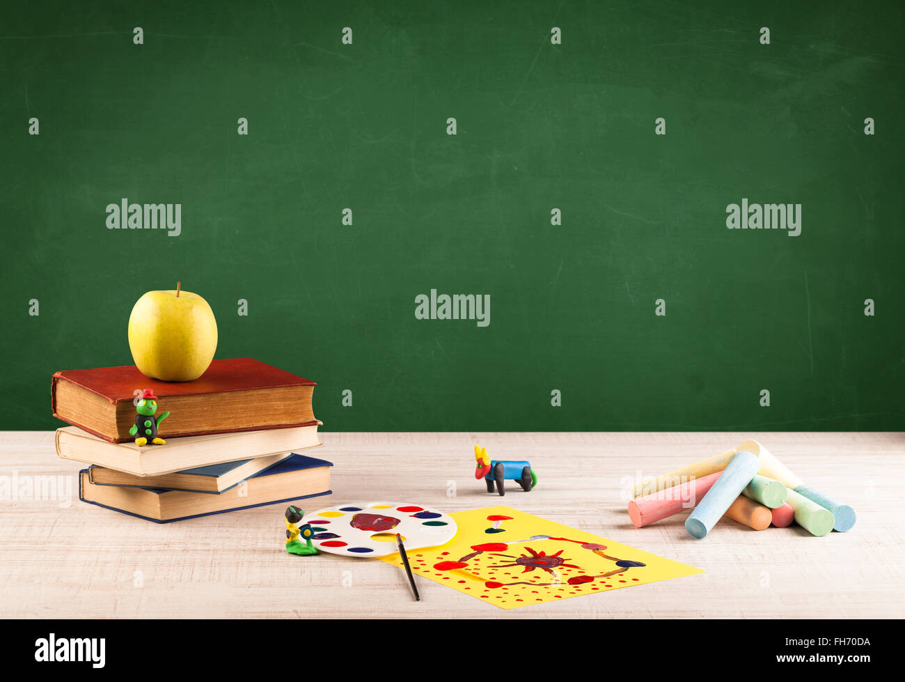 School items on desk with empty chalkboard Stock Photo - Alamy