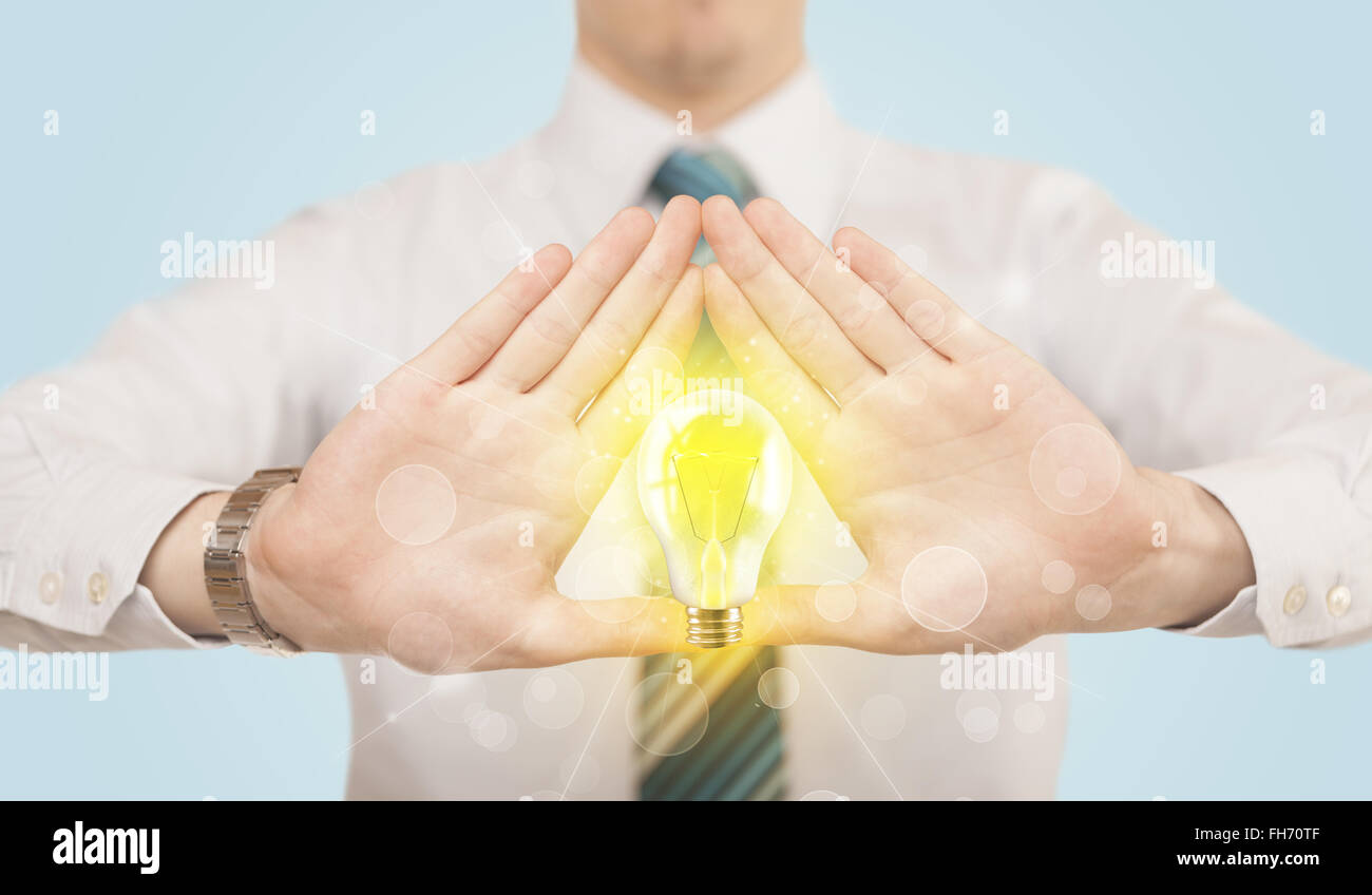 Hands creating a form with light bulb Stock Photo - Alamy