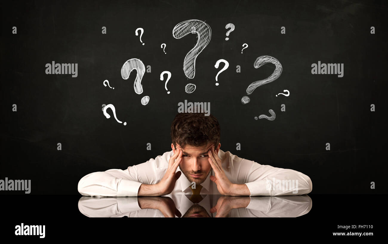 Sitting businessman under question marks Stock Photo - Alamy