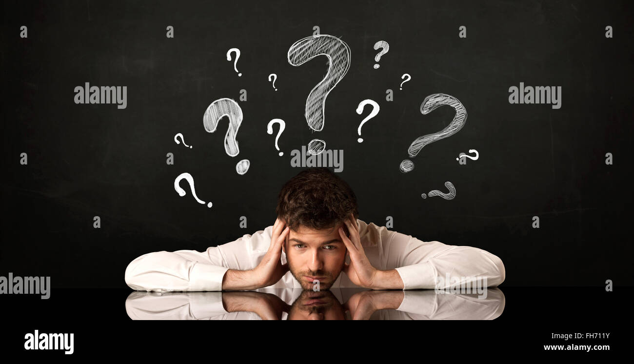Sitting businessman under question marks Stock Photo - Alamy