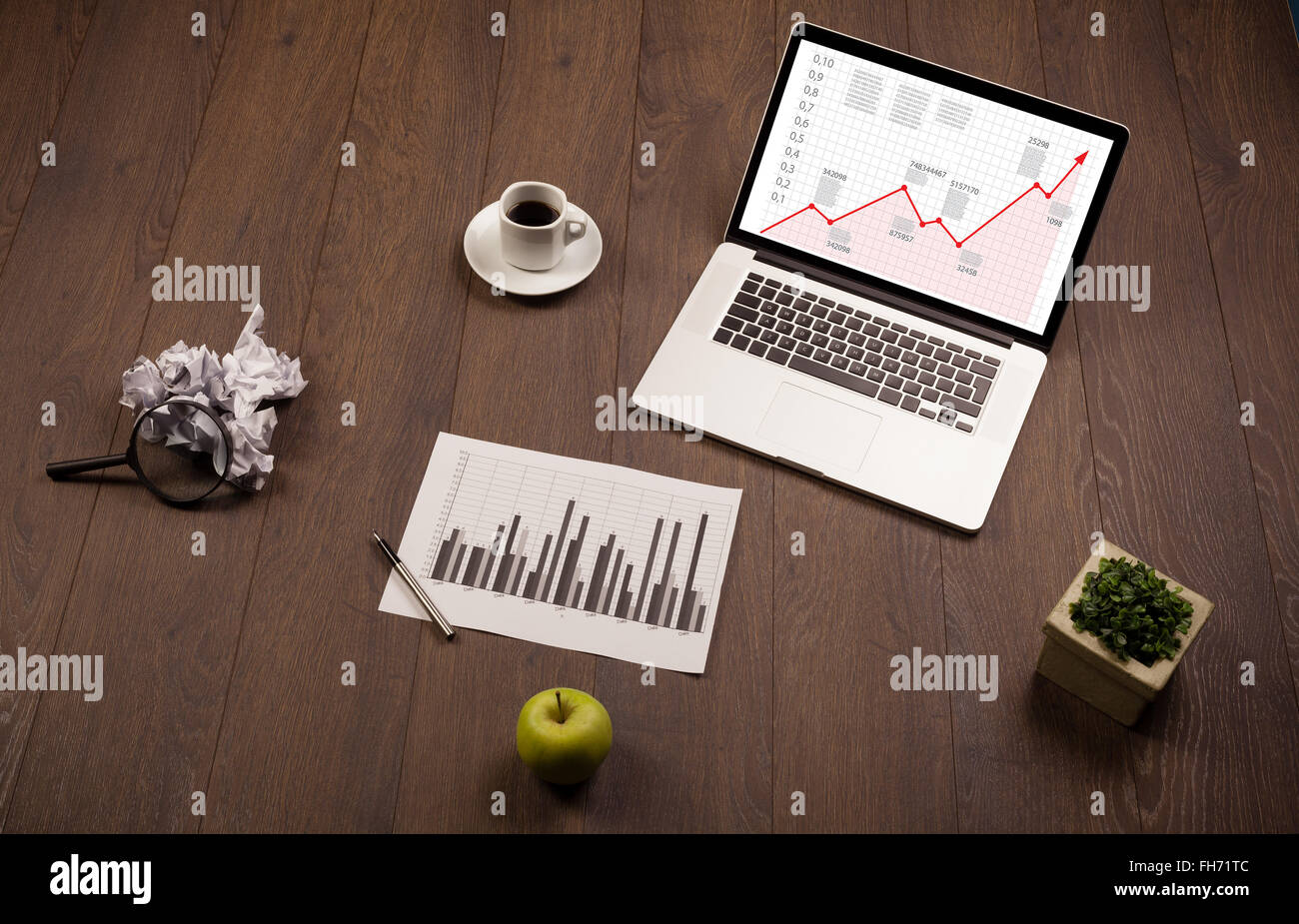 Computer desk with laptop and red arrow chart in screen Stock Photo - Alamy