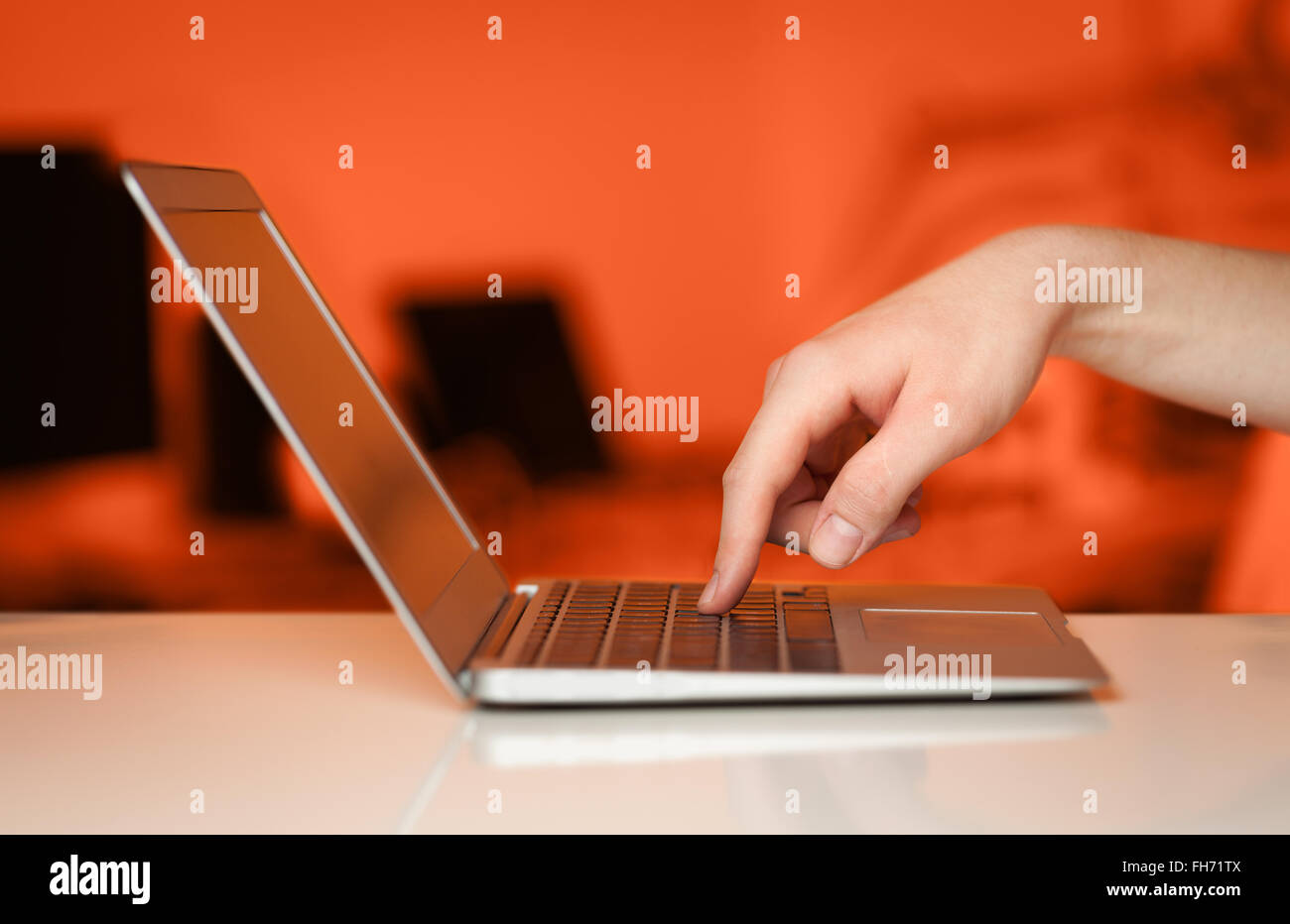Businessman pressing modern laptop computer on colorful background ...