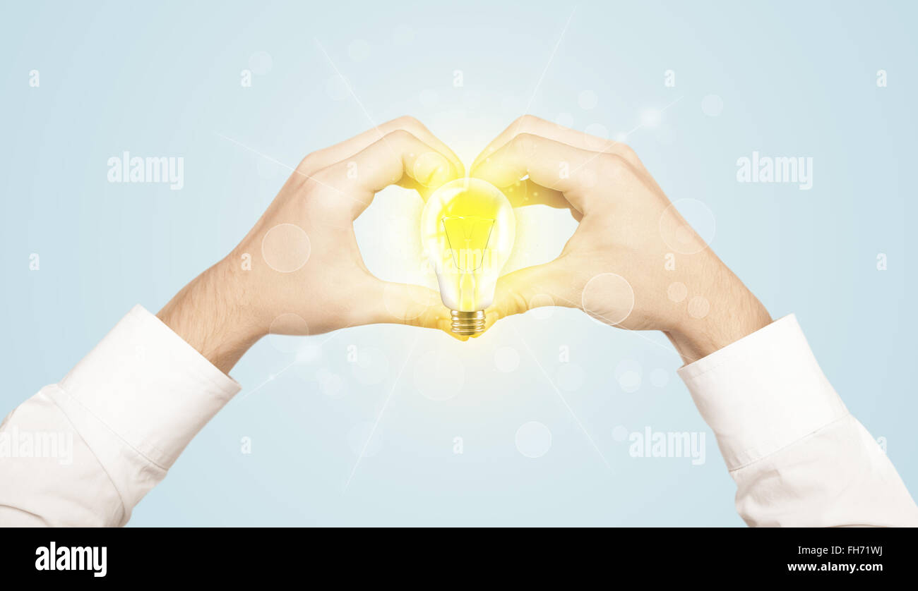 Hands creating a form with light bulb Stock Photo - Alamy