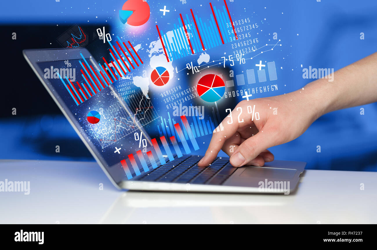 Hand typing on modern laptop notebook computer with graph icons and ...