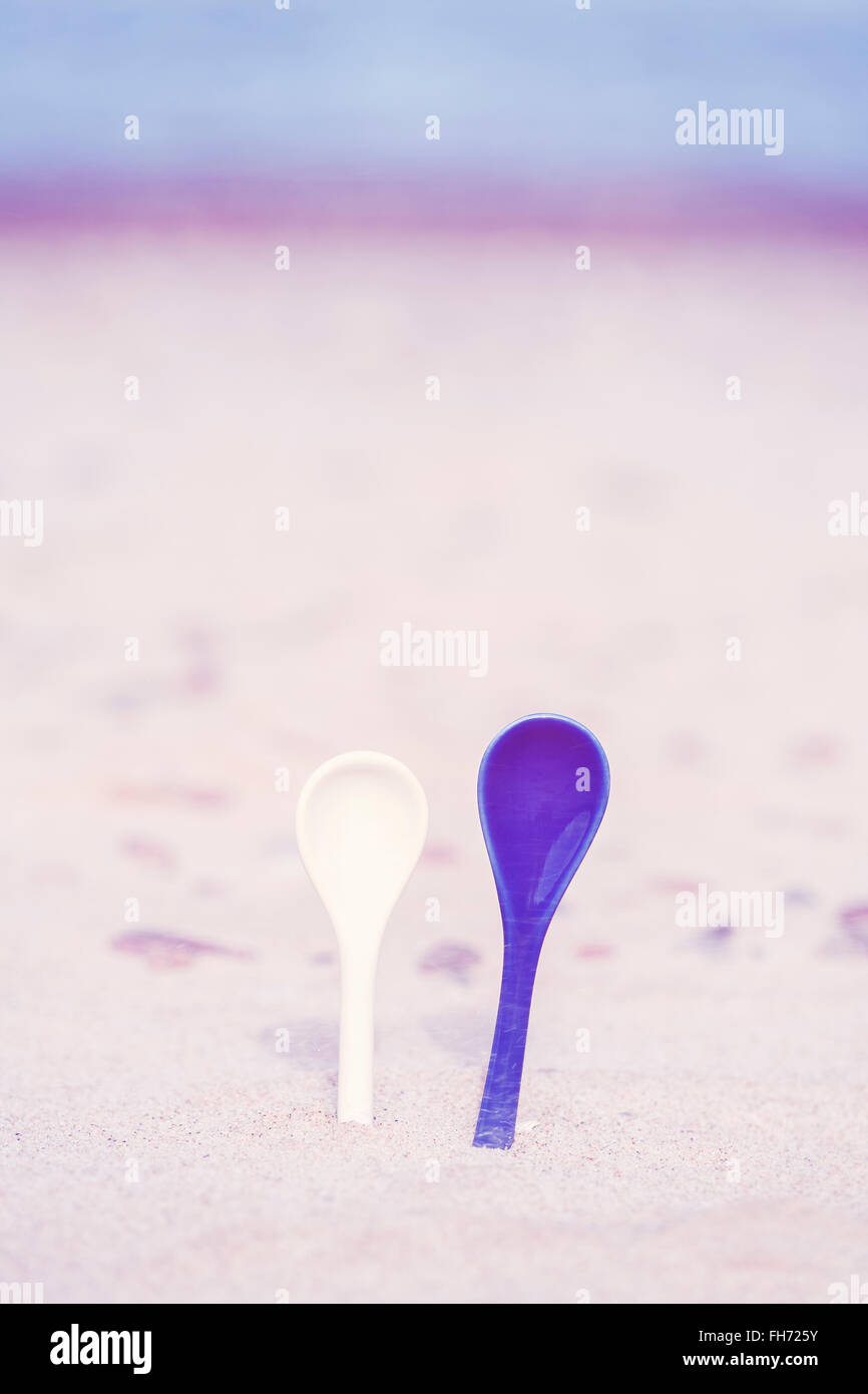 Vintage stylized two porcelain spoons stuck in sand Stock Photo - Alamy