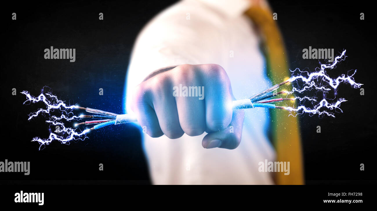 Business person holding electrical powered wires Stock Photo - Alamy
