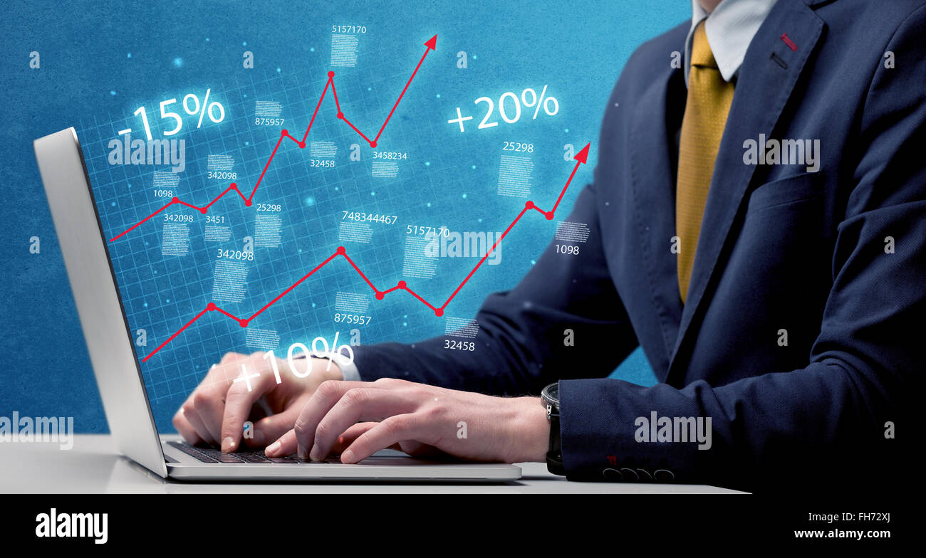 Salesman working on graph with laptop Stock Photo - Alamy
