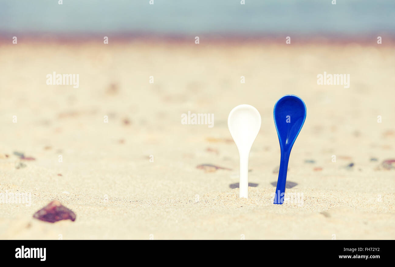 Vintage stylized two porcelain spoons stuck in sand Stock Photo - Alamy