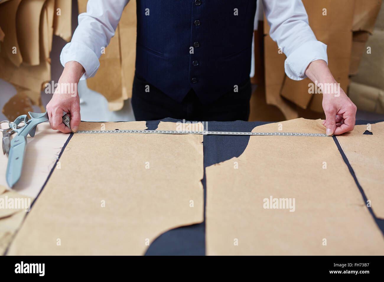 Modern tailor measuring paper patterns during work Stock Photo - Alamy