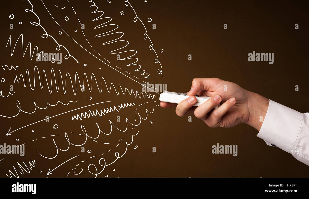 Hand with remote control and curly lines Stock Photo - Alamy