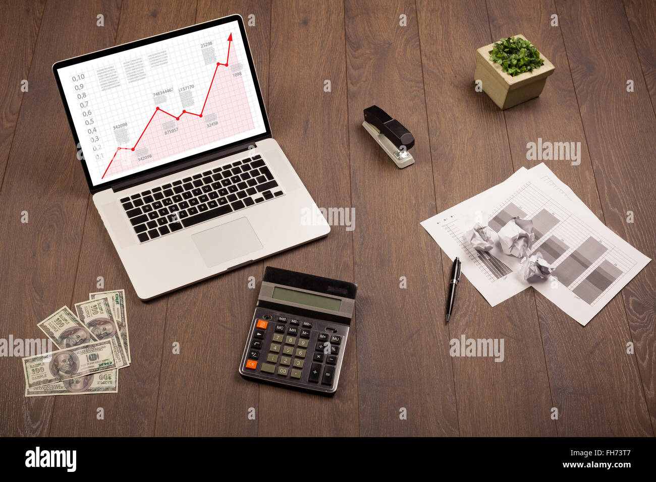 Computer desk with laptop and red arrow chart in screen Stock Photo - Alamy
