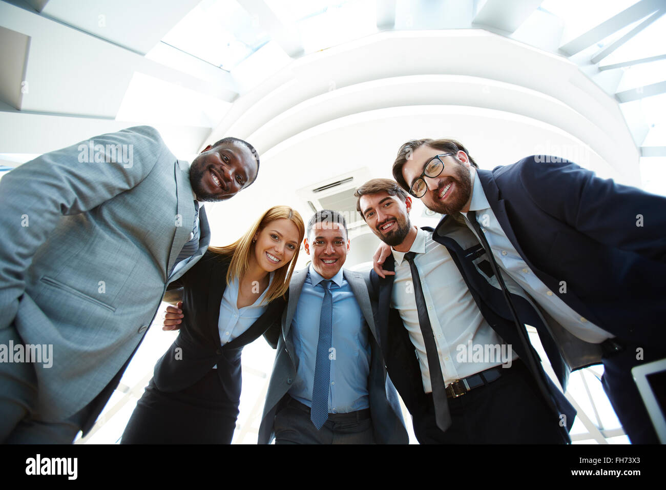Group of happy managers in formal-wear looking at camera Stock Photo ...