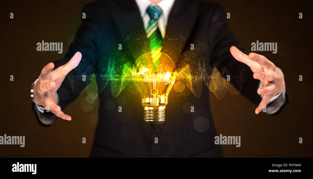 Businessman holding light bulb Stock Photo - Alamy